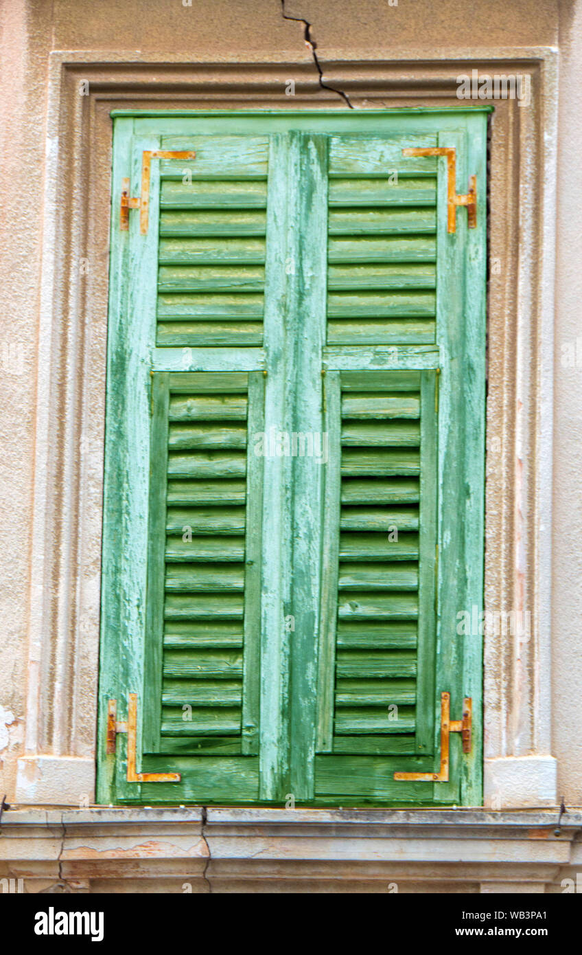 An old rustic window with wooden shutters and rusty hinges. - image ...