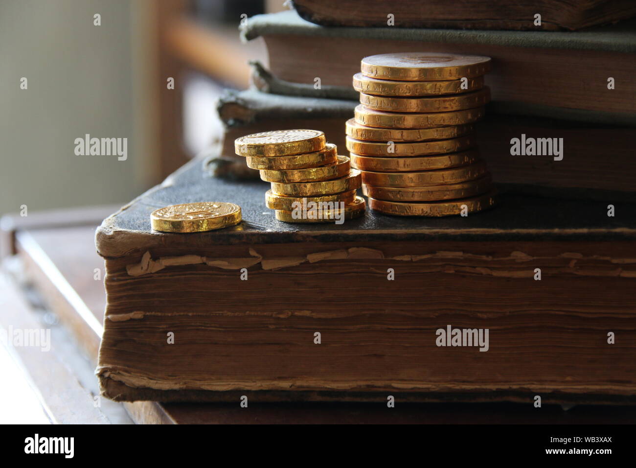 Money growth idea. Stacks of gold coins and vintage books Stock Photo ...