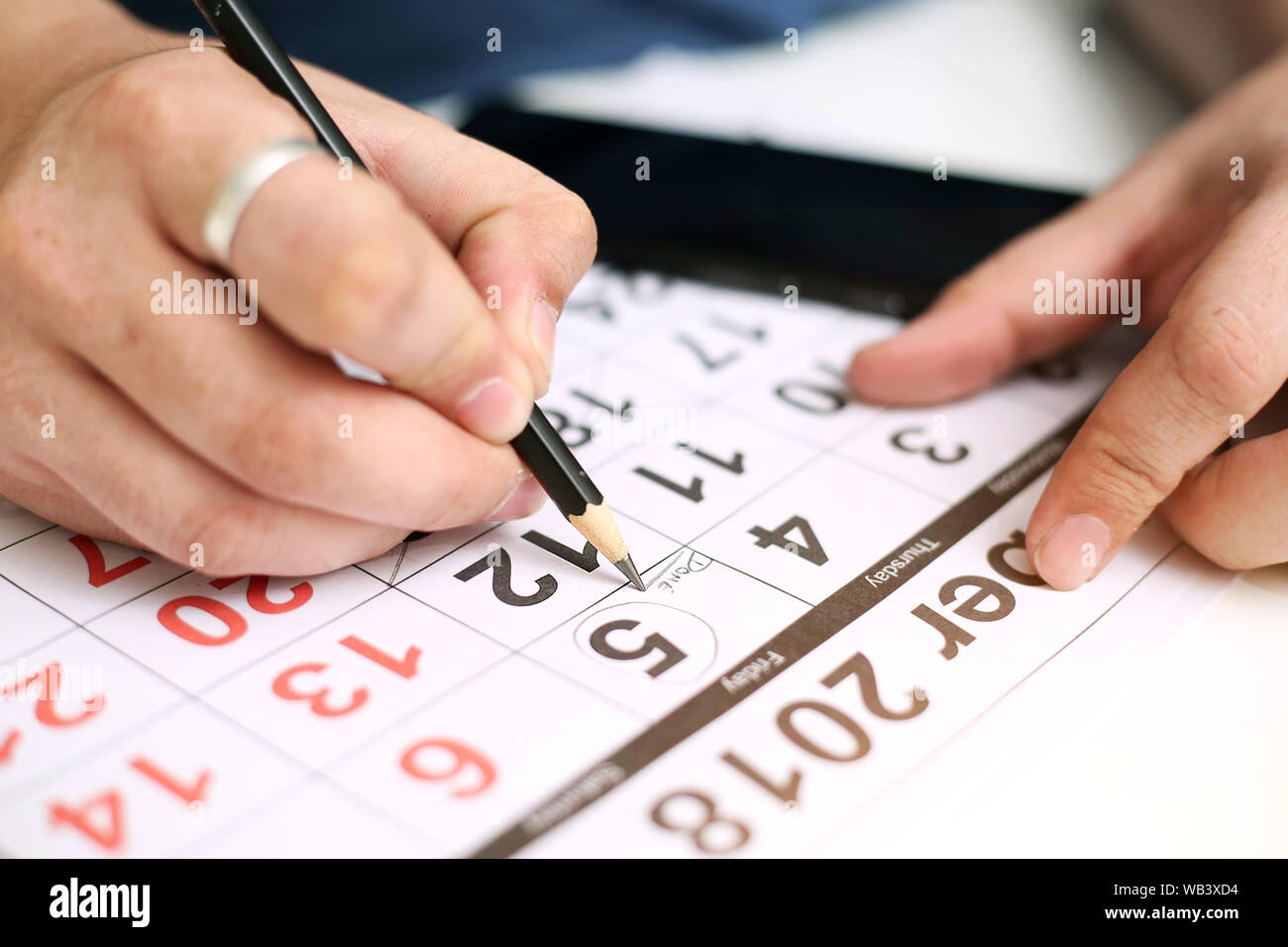 Picture of Man holding Calendar and marking on a date. Isolated on ...