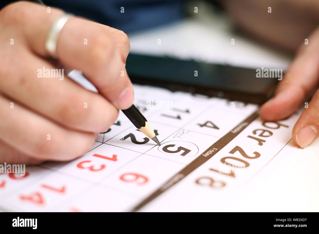 Picture of Man holding Calendar and marking on a date. Isolated on ...