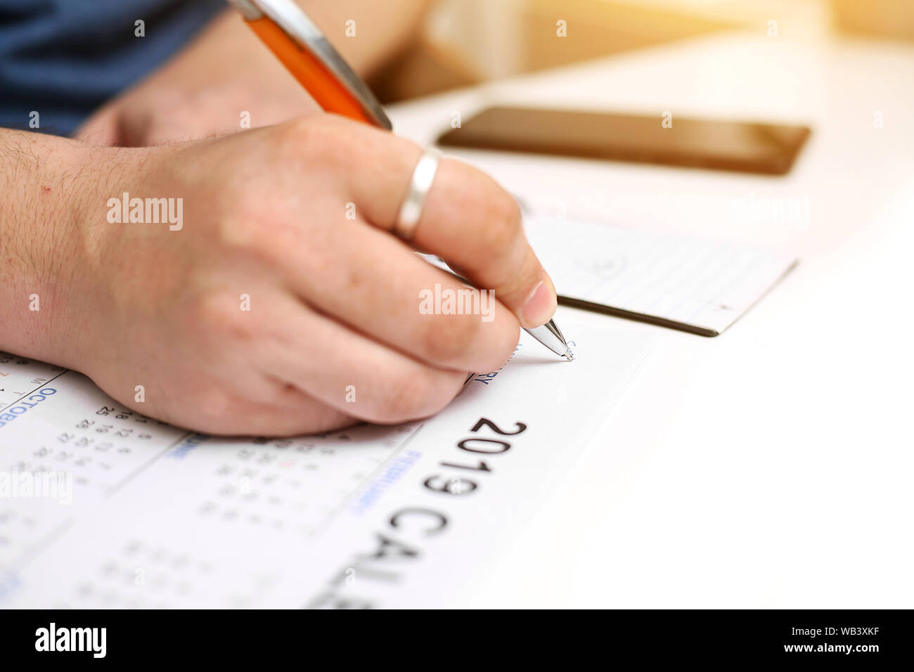 Picture of Man holding Calendar and marking on a date. Isolated on ...