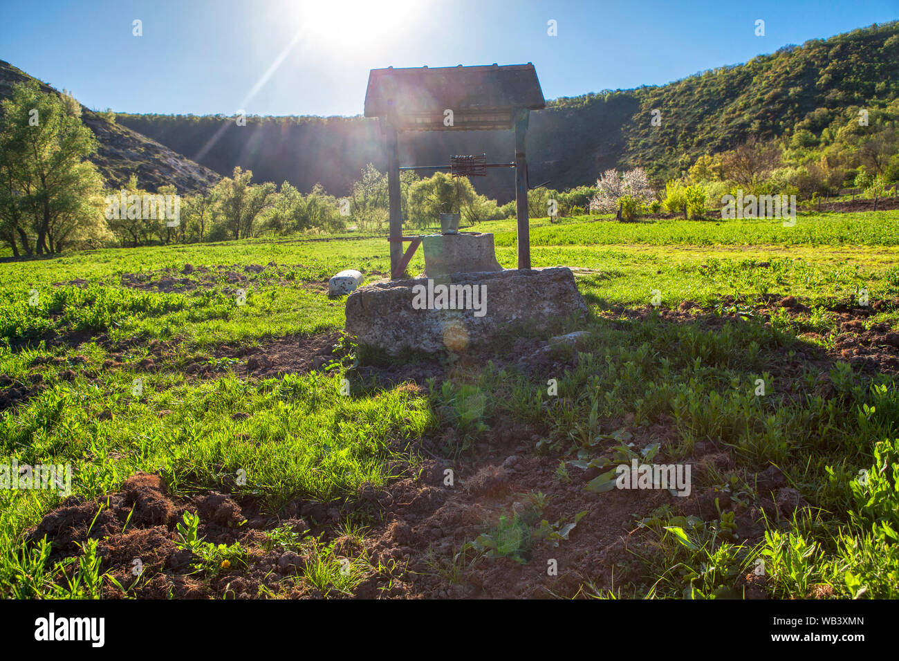 spring landscape with green meadow and water well Stock Photo - Alamy