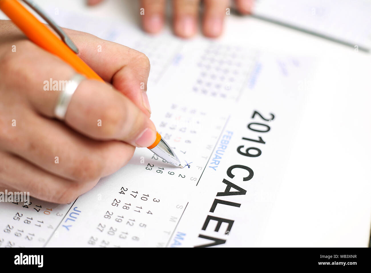 Picture of Man holding Calendar and marking on a date. Isolated on ...