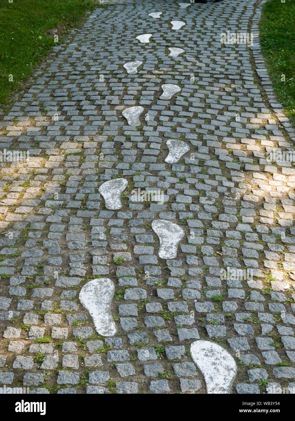 white painted footprints on a cobblestone path leading upwards Stock ...