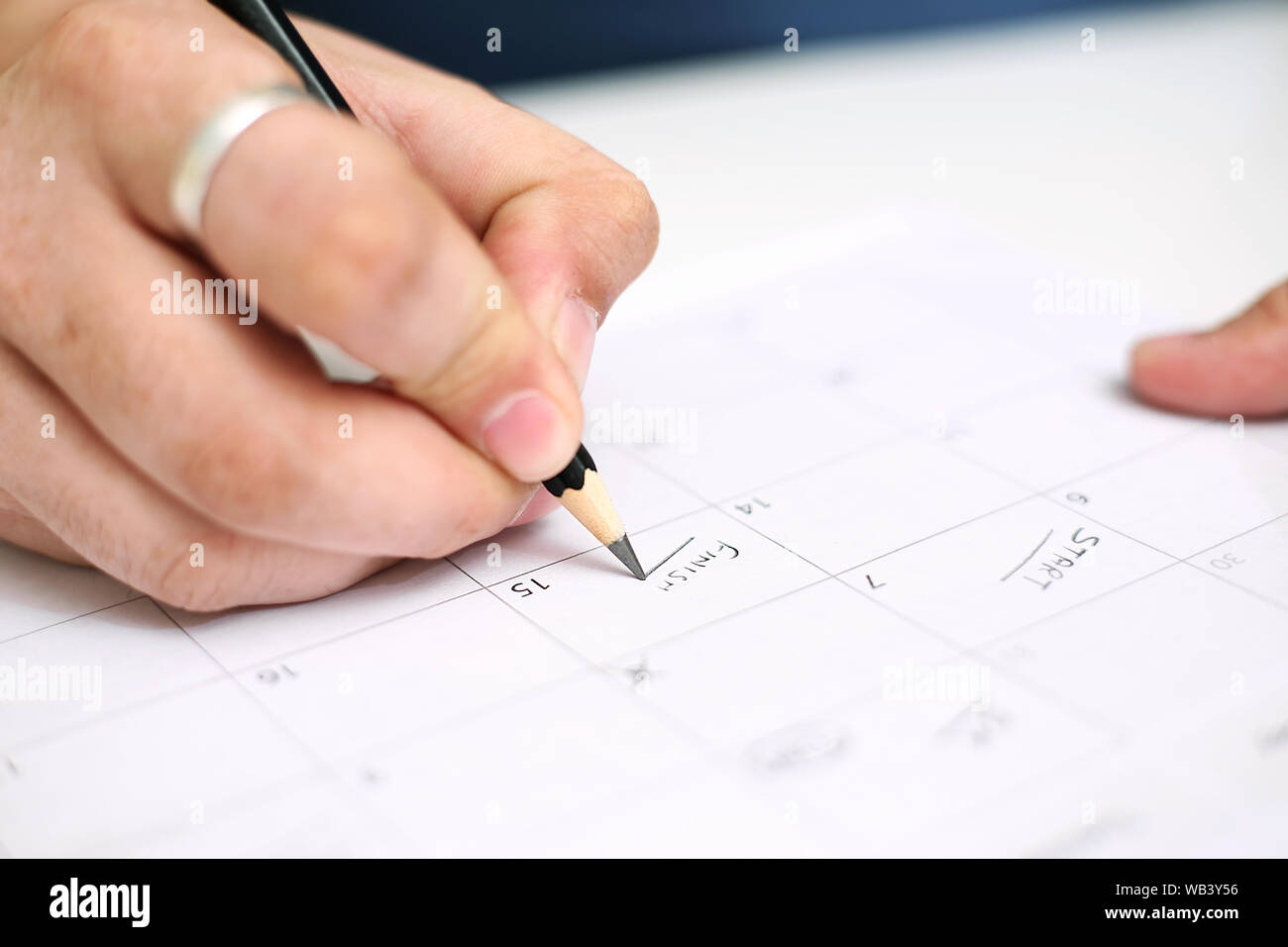 Picture of Man holding Calendar and marking on a date. Isolated on ...