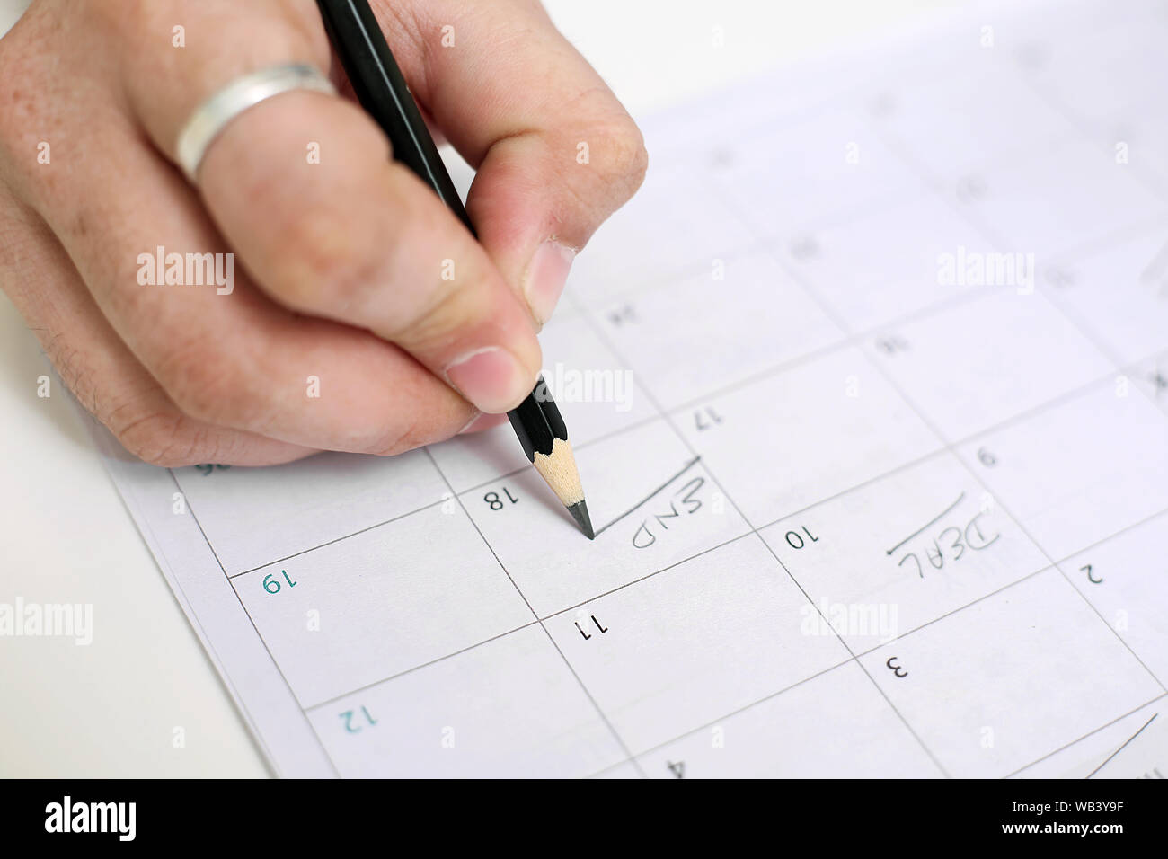 Picture of Man holding Calendar and marking on date. Isolated on white ...