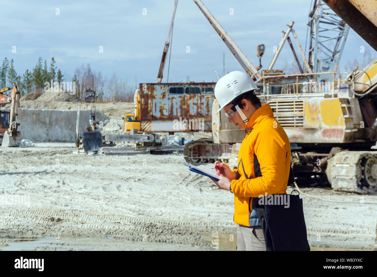 female geologist or a mining engineer writes something in a map-case ...