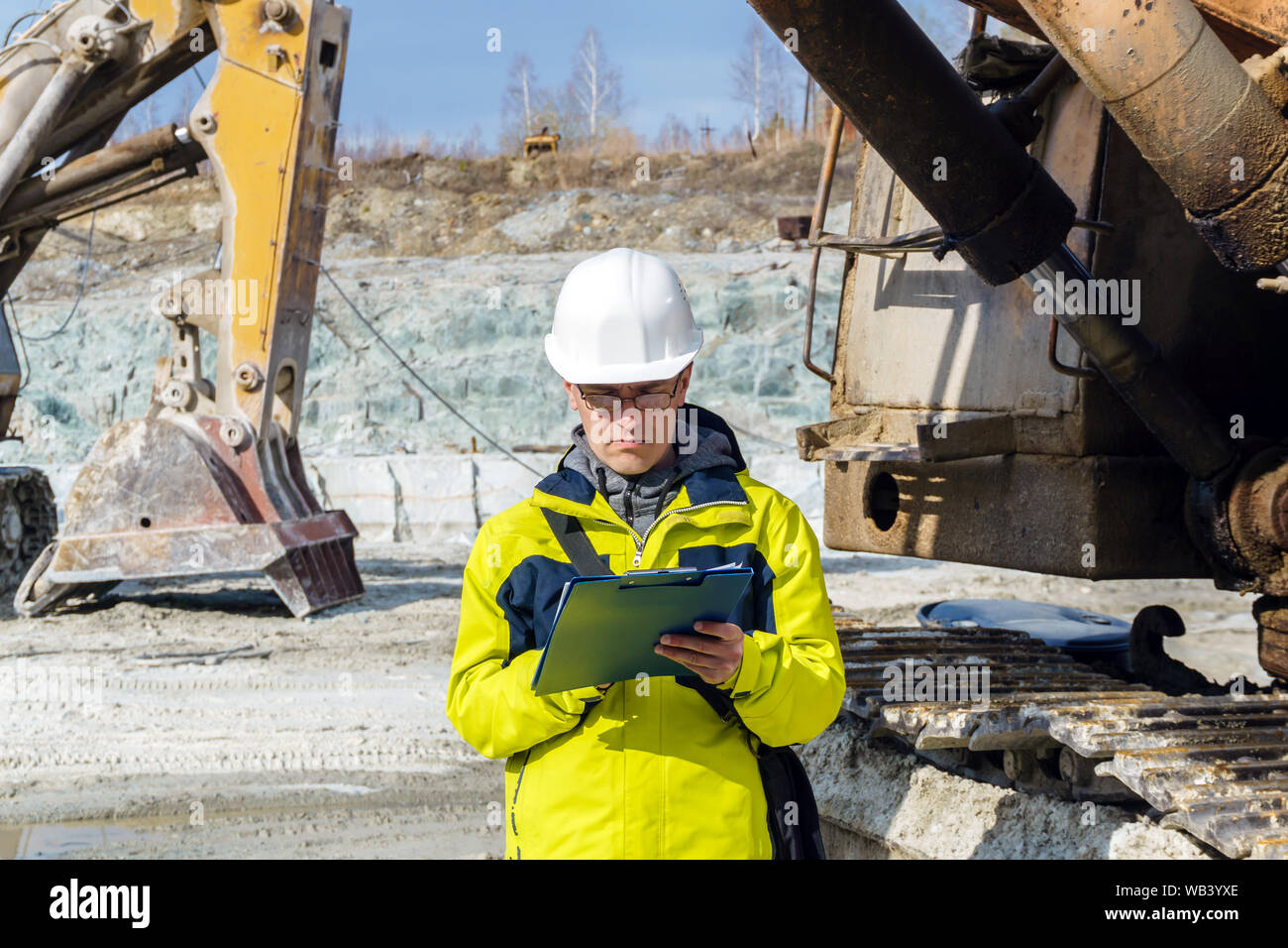 man geologist or a mining engineer writes something in a map-case amid ...