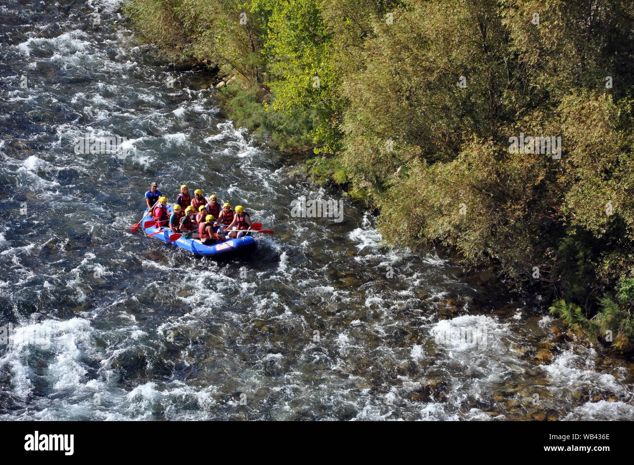 Rafting, a group of young people with a guide rafting along a mountain ...