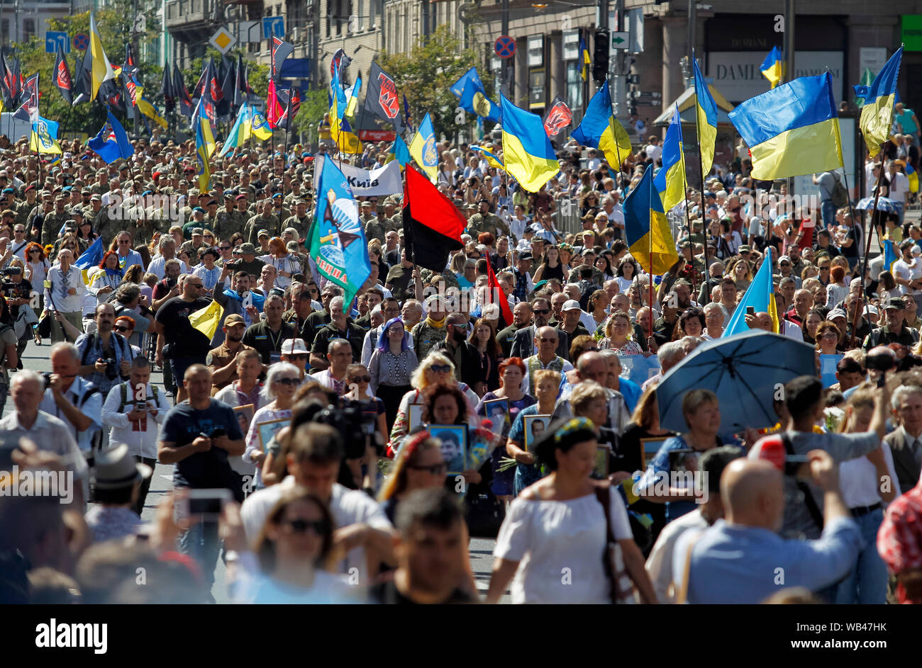 People march while holding flags at the Independence Square during the ...