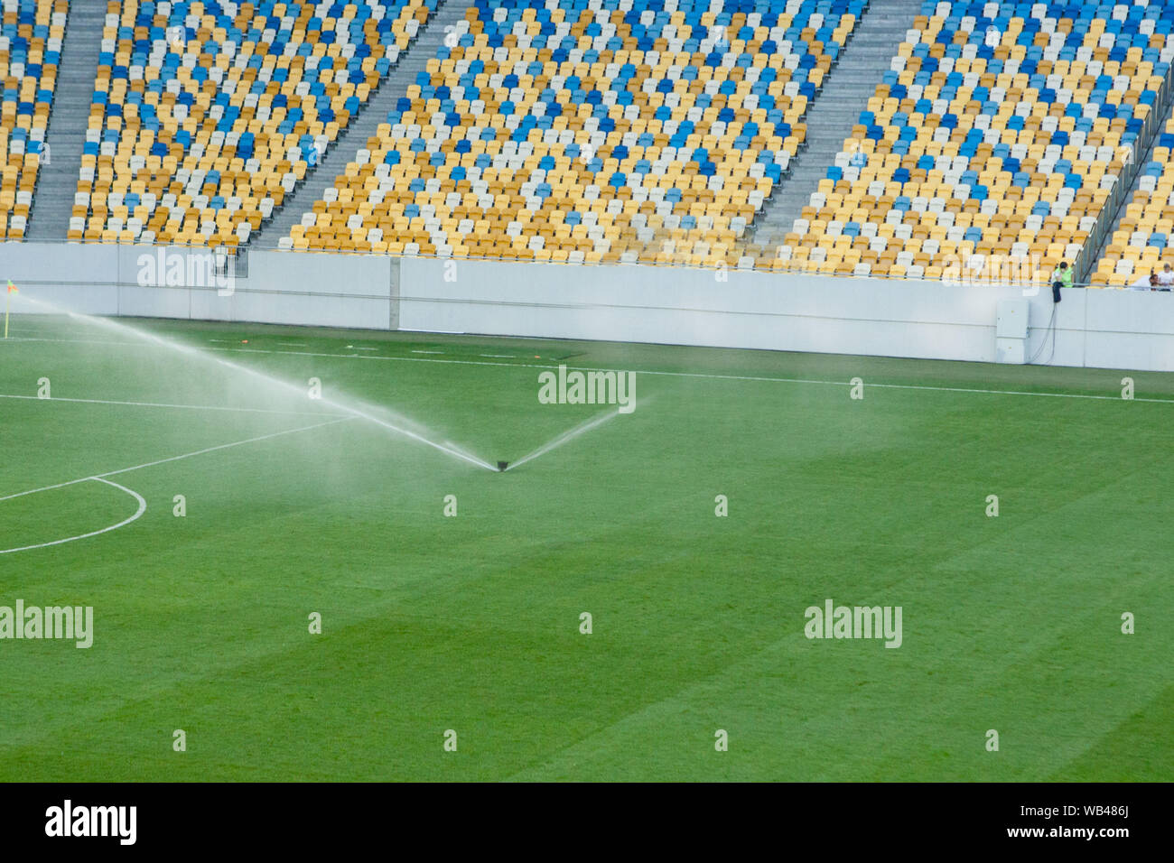 Automatic lawn grass watering system at the stadium. A football, soccer ...