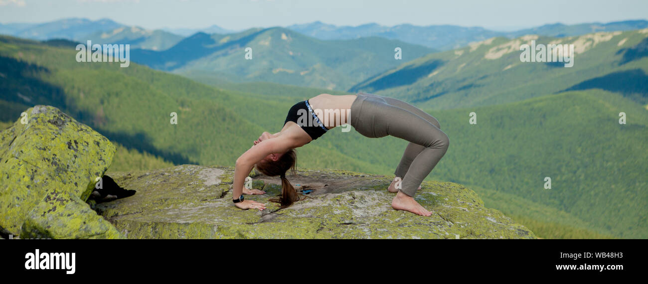 Girl doing yoga exercise lotus pose at the top of the mountain Stock ...