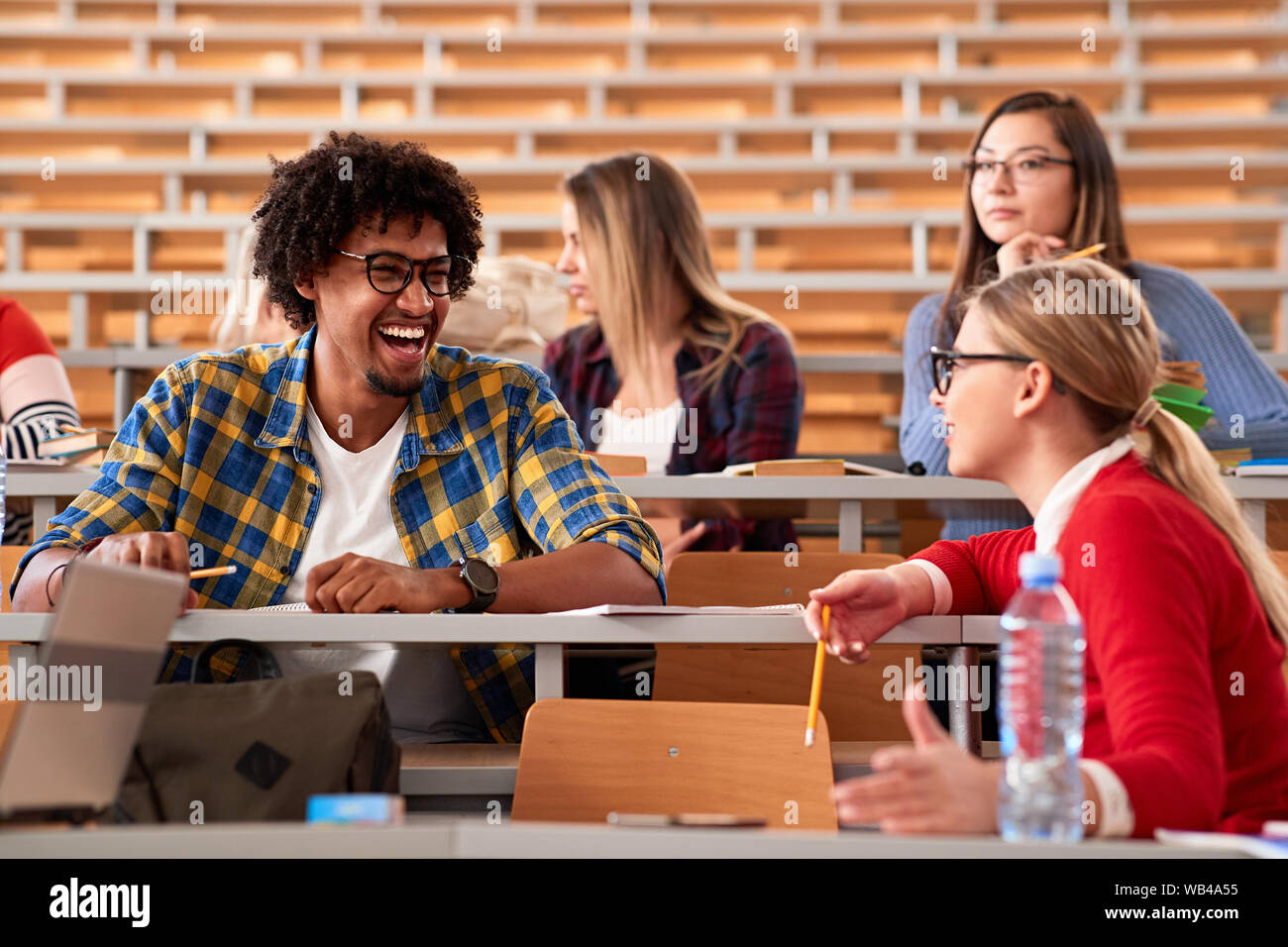 Smiling young friends studying together at university campus Stock ...