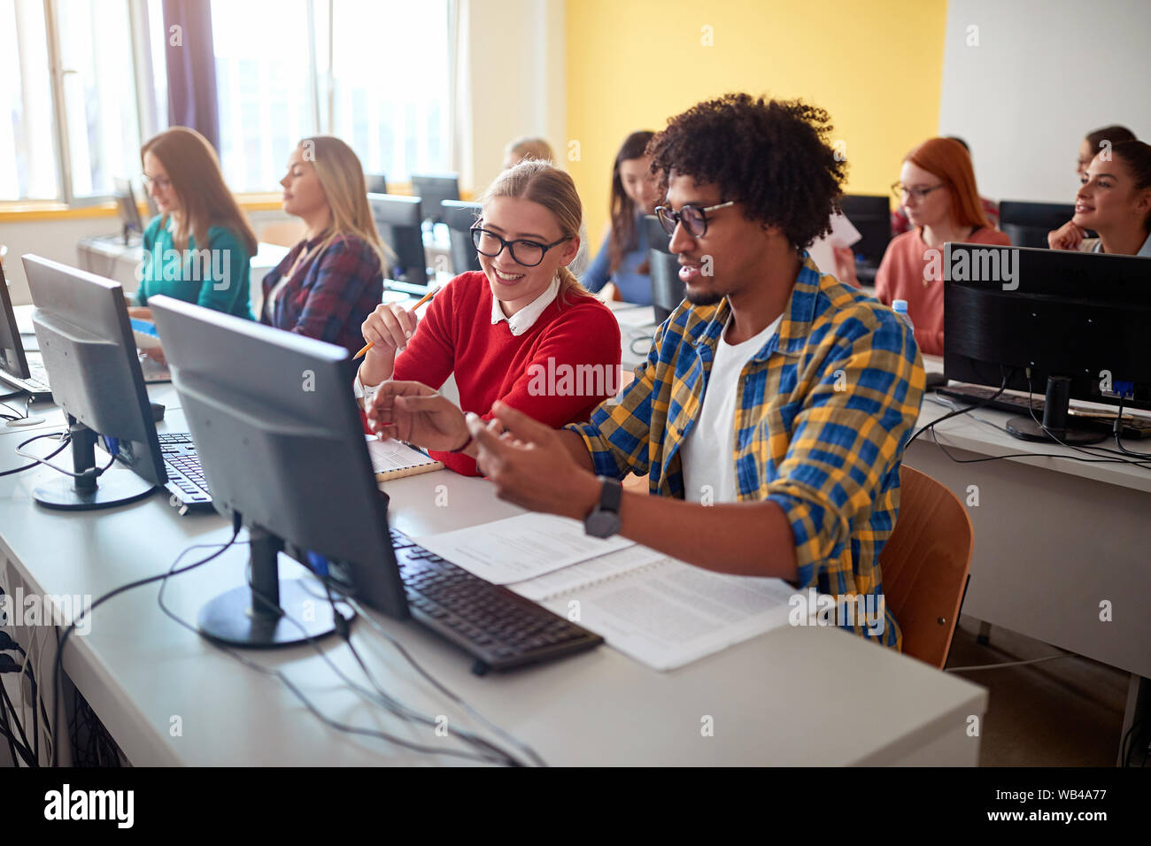 Smiling students sitting table using hi-res stock photography and ...