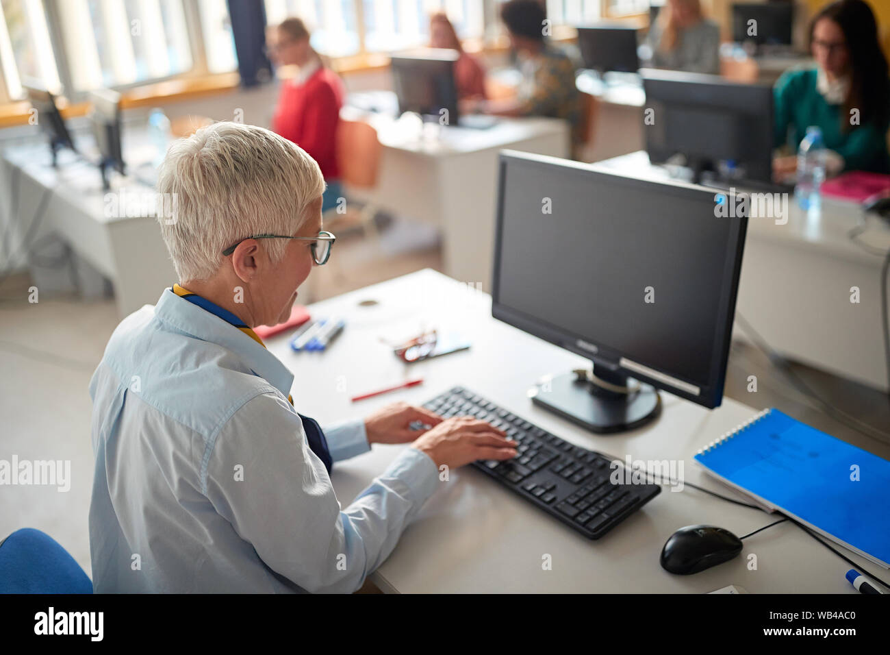 Teacher lecturer on class working on computer on university campus ...