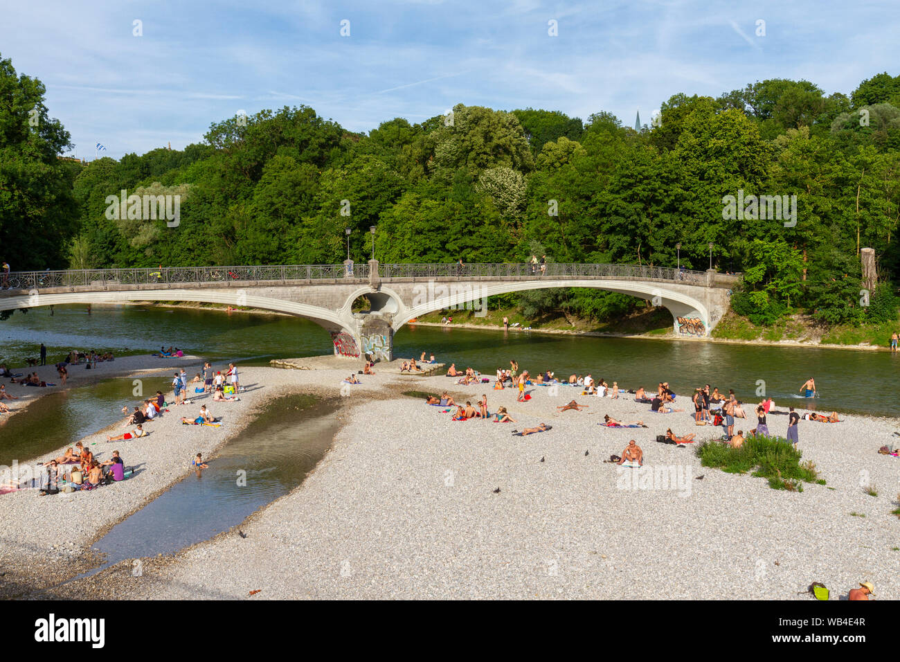 Sun worshipers beside the Kabelsteg (cable bridge) and the Isar during ...