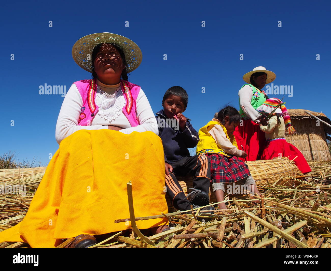 An indigenous Uro family sitting on their own floating island of Totora ...