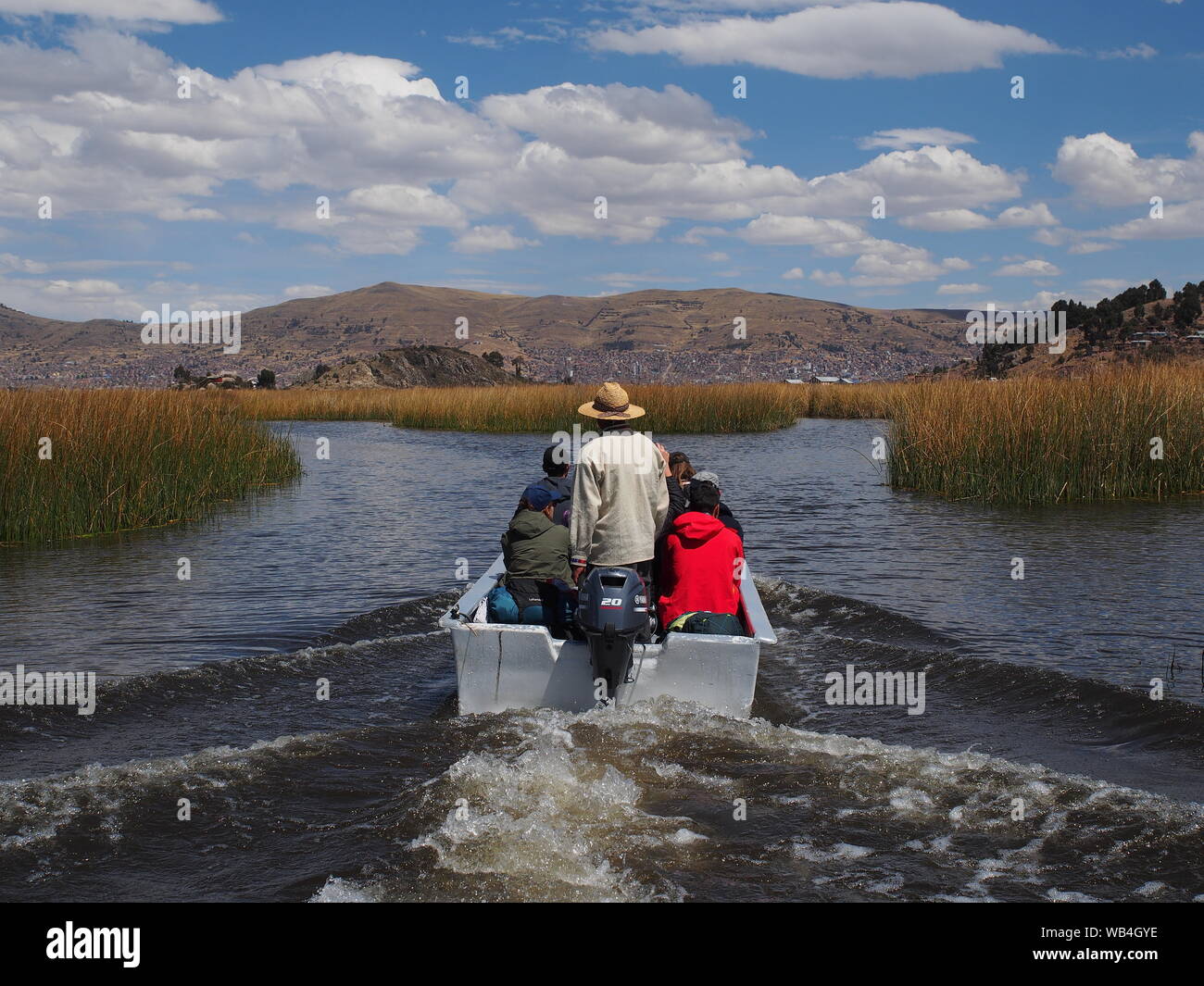 A Uro family onboard a motor boat sailing among the totora reed in ...