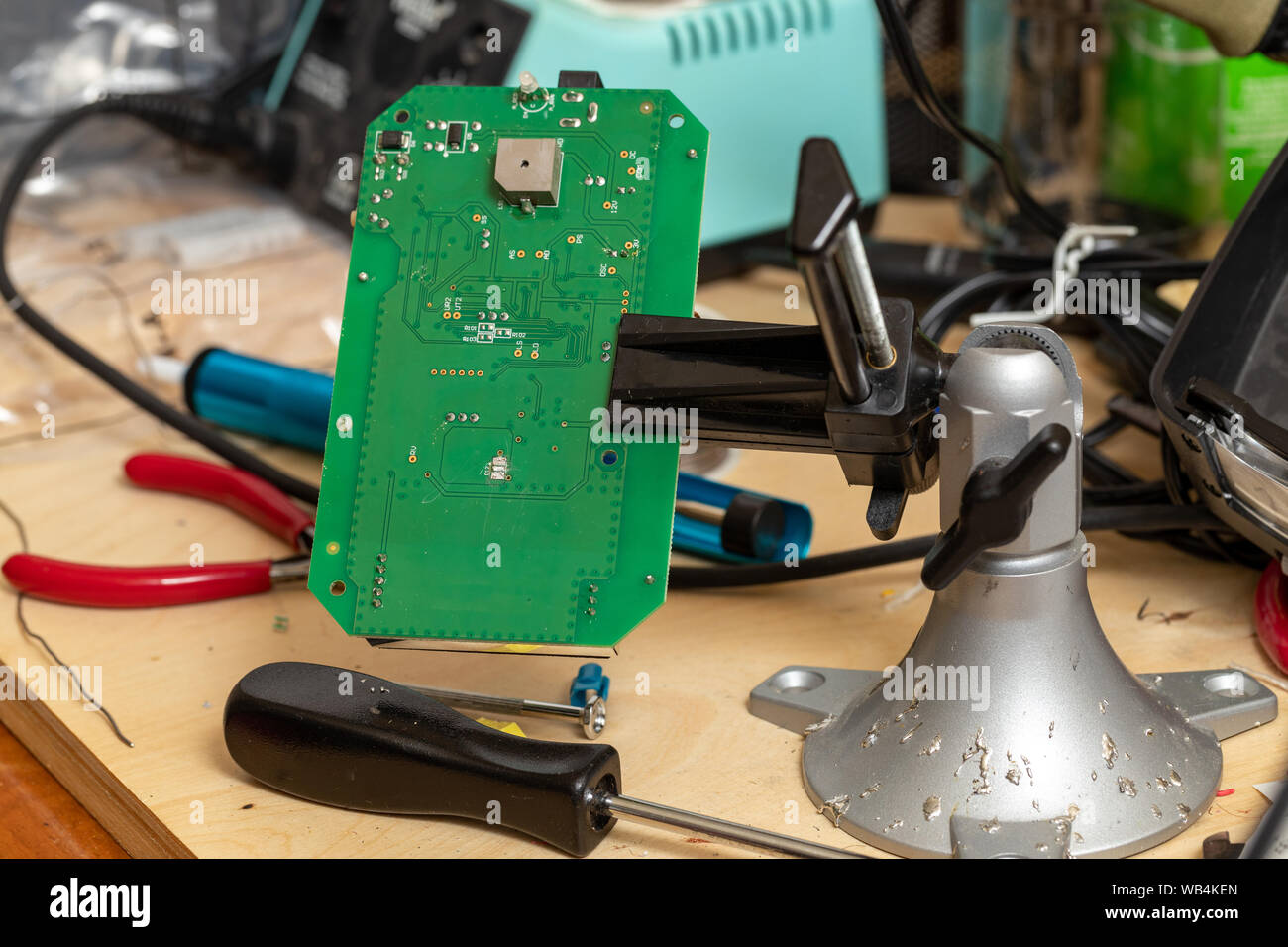 Printed circuit board in vice on workbench for repair Stock Photo - Alamy
