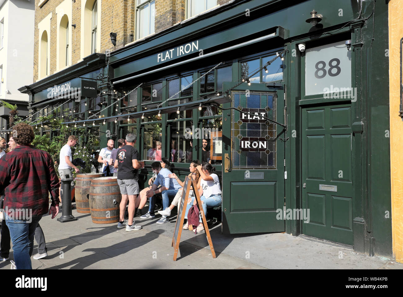 Flat iron pub and people tourists sitting outside drinking in summer on ...
