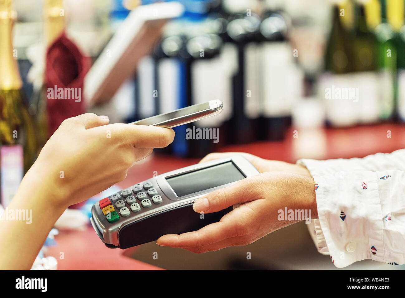 The buyer pays for the item at the cash register using a smartphone ...