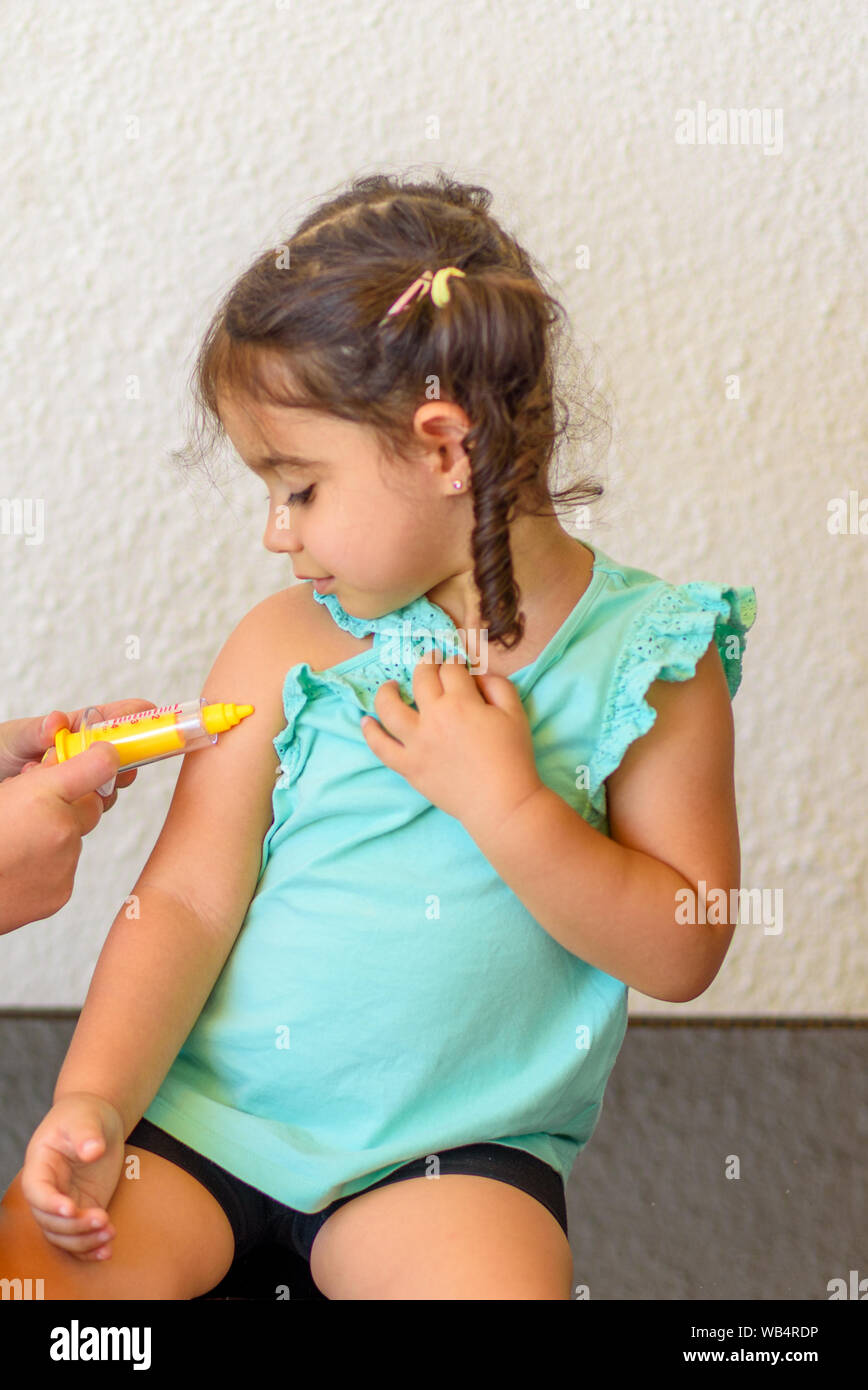 Children playing doctor. Doctor injecting vaccination Flu Shot in arm ...