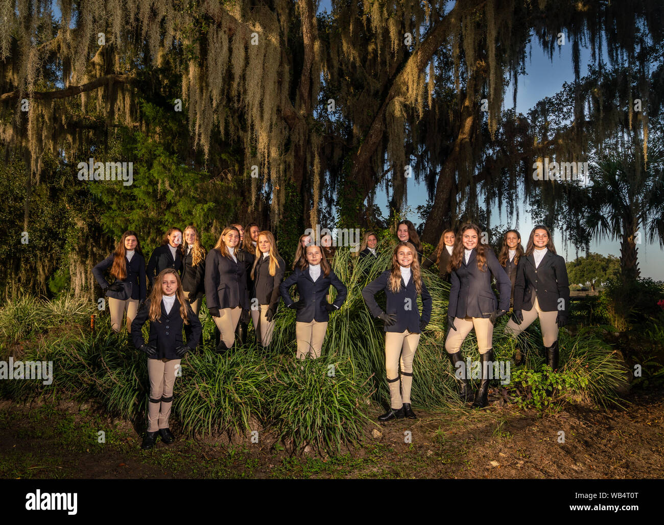 A group of young female english riders in uniform are posing for the ...