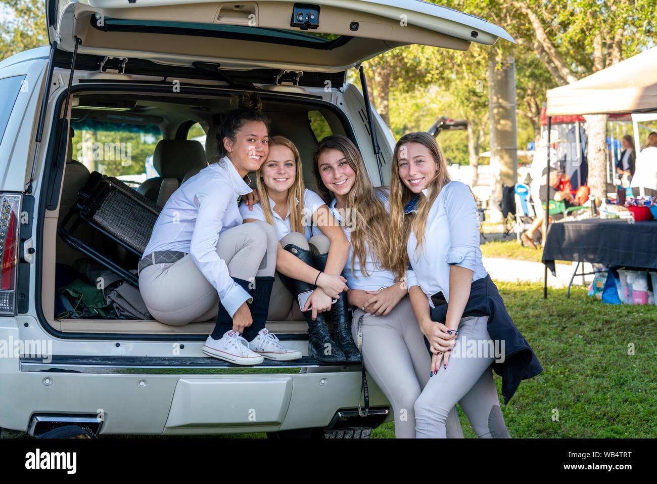 A group of high school equestrian girls are posing for the camera ...