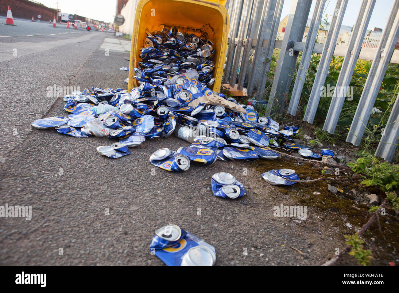 Yellow recycle box with hundreds of beer cans scattered on the street ...
