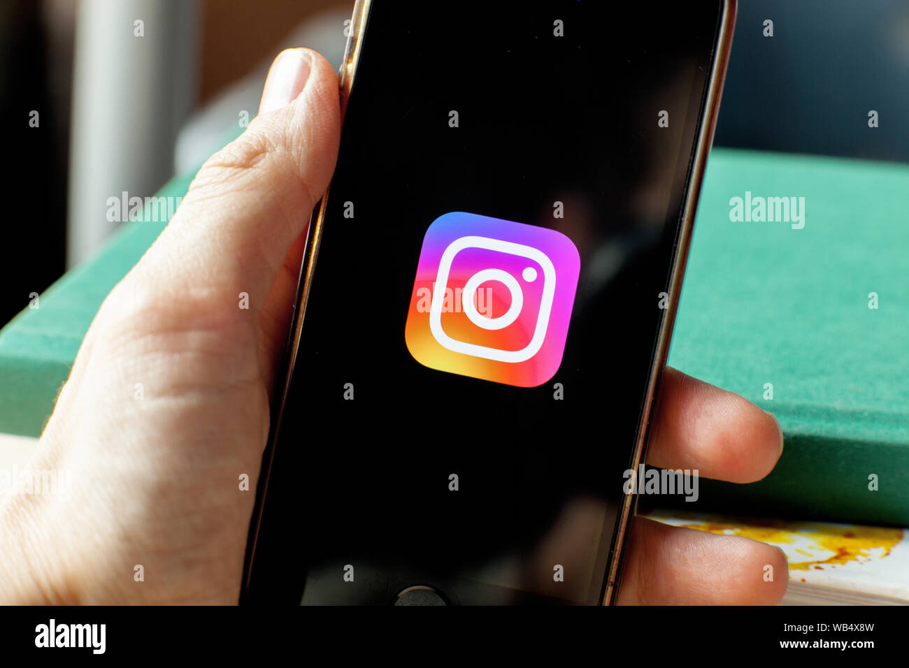 Hand holding a smartphone with an Instagram icon on screen. IPhone with ...