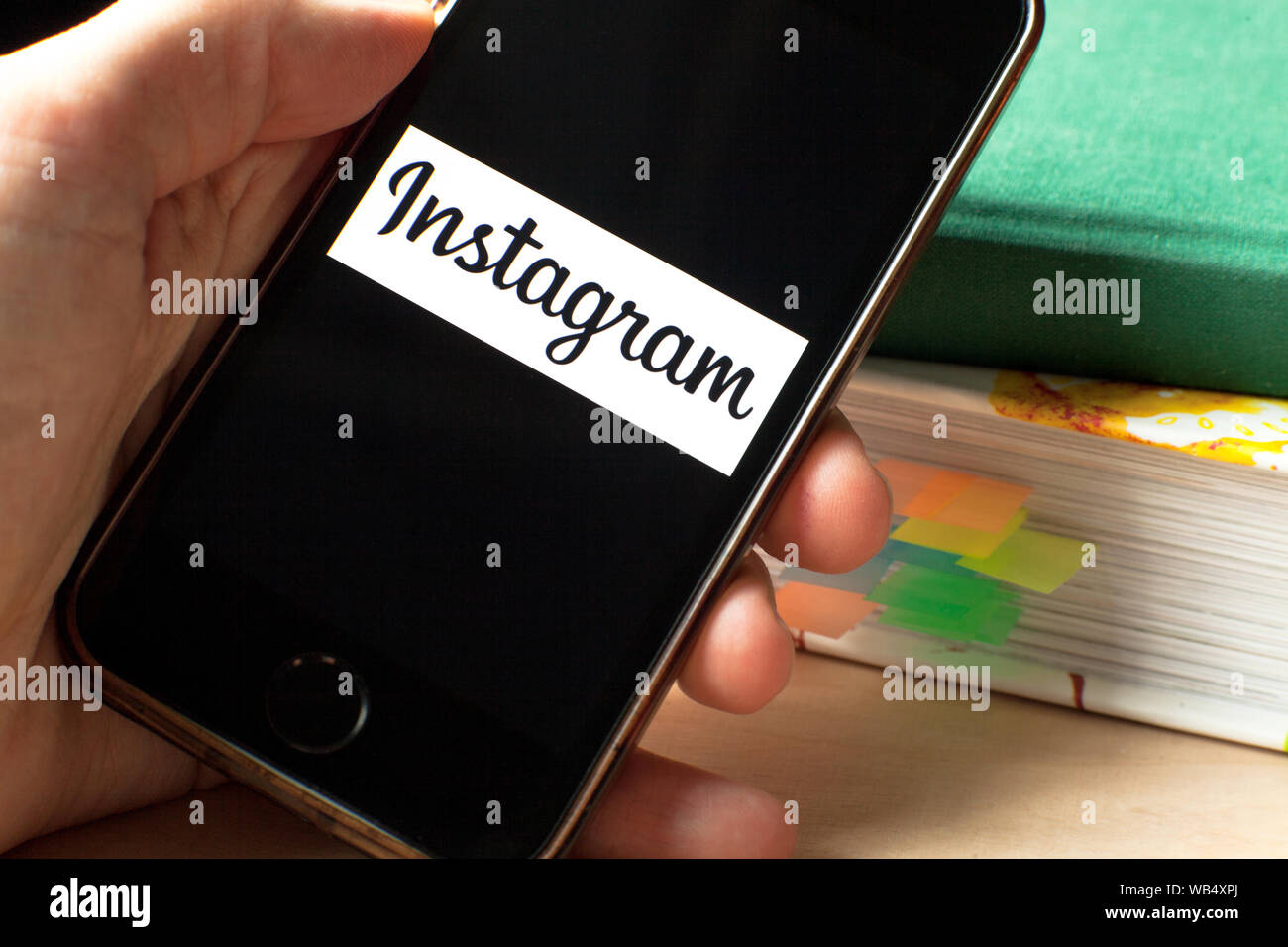 Hand holding a smartphone with an Instagram icon on screen. IPhone with ...