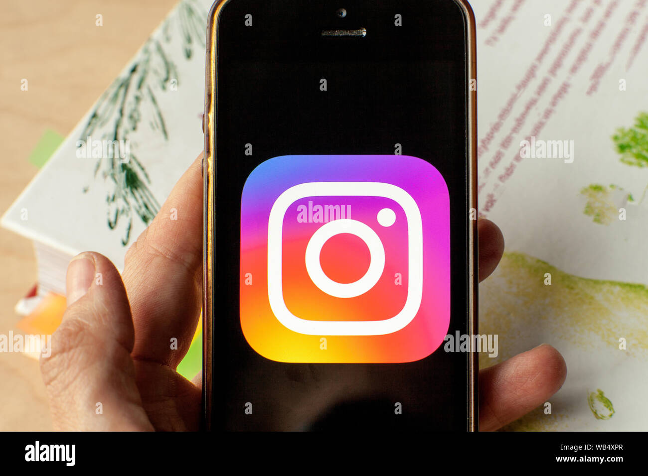 Hand holding a smartphone with an Instagram icon on screen. IPhone with ...