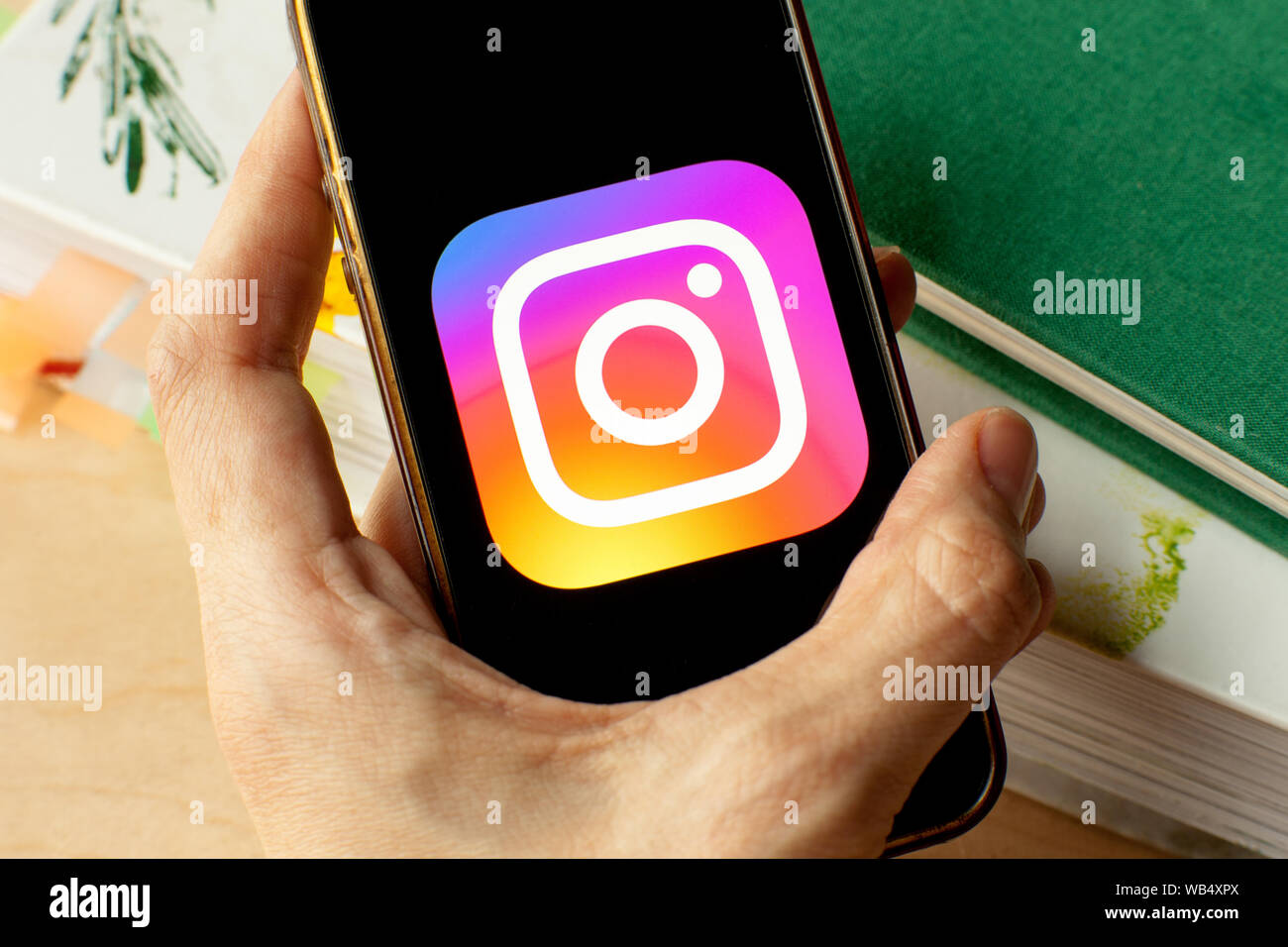 Hand holding a smartphone with an Instagram icon on screen. IPhone with ...
