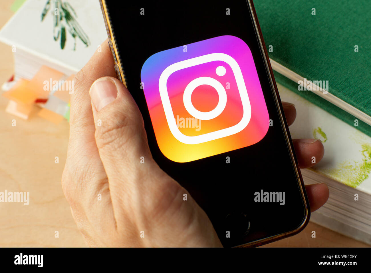 Hand holding a smartphone with an Instagram icon on screen. IPhone with ...