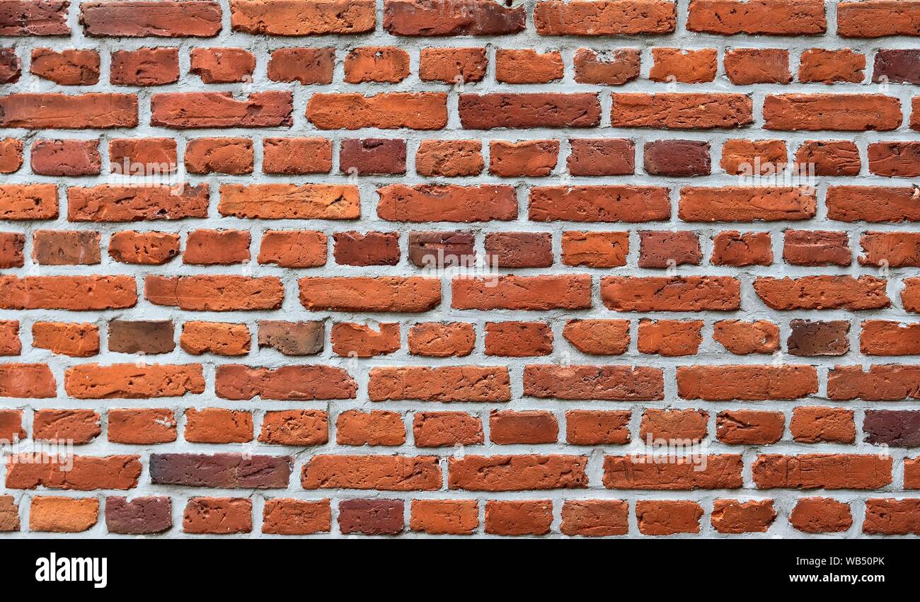 Detailed close up view on an aged and weathered red brick wall texture ...