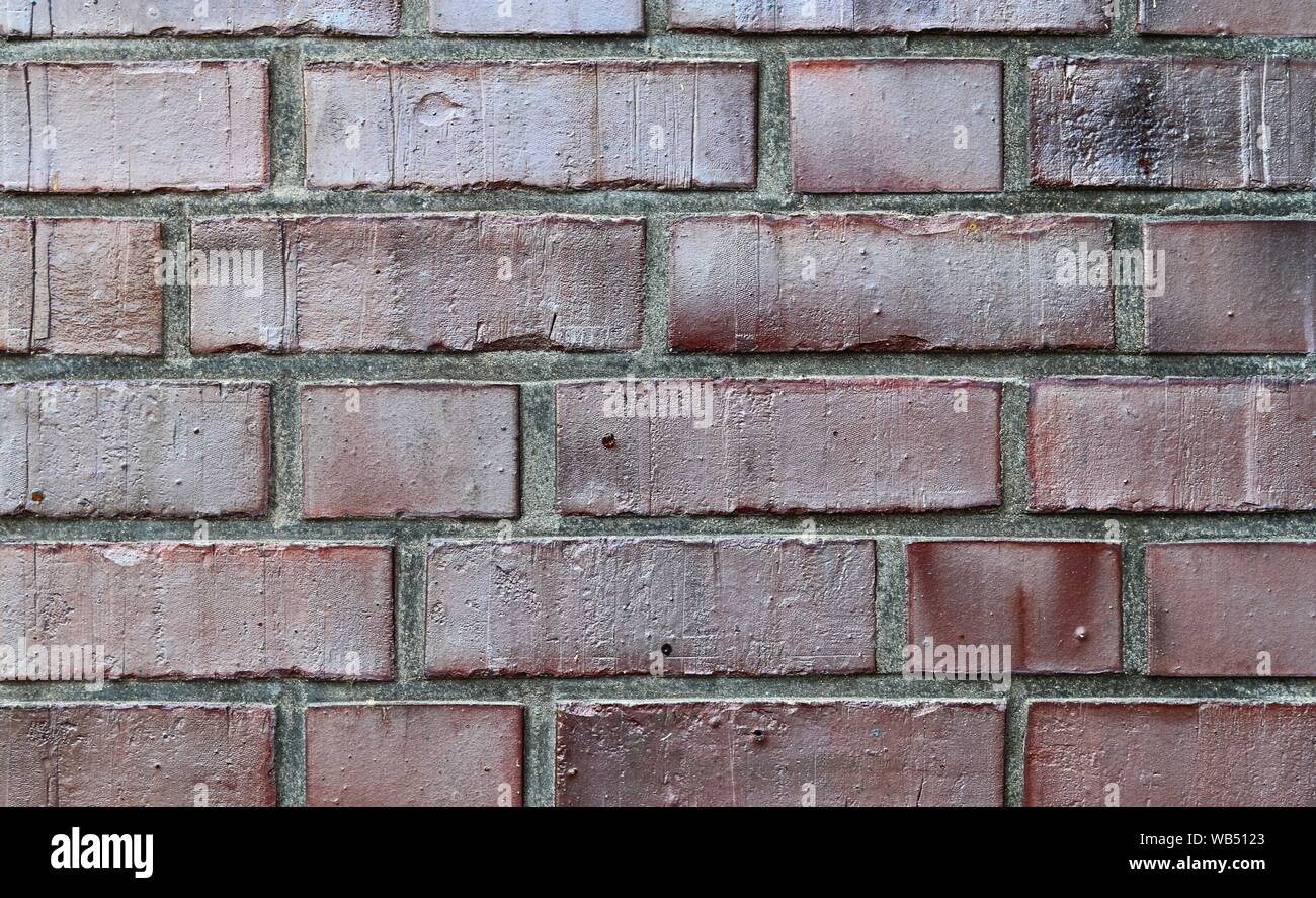 Detailed close up view on an aged and weathered red brick wall texture ...