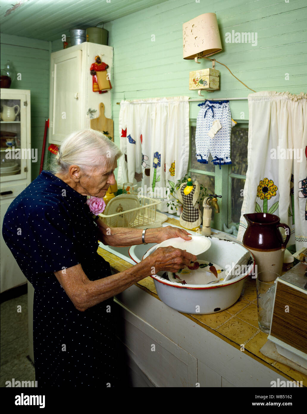 Elderly woman washing dishes in her cabin, Madison, North Carolina ...