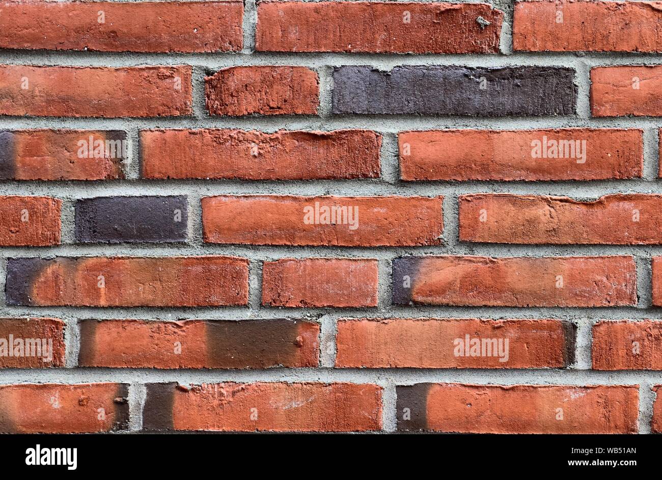 Detailed close up view on an aged and weathered red brick wall texture ...