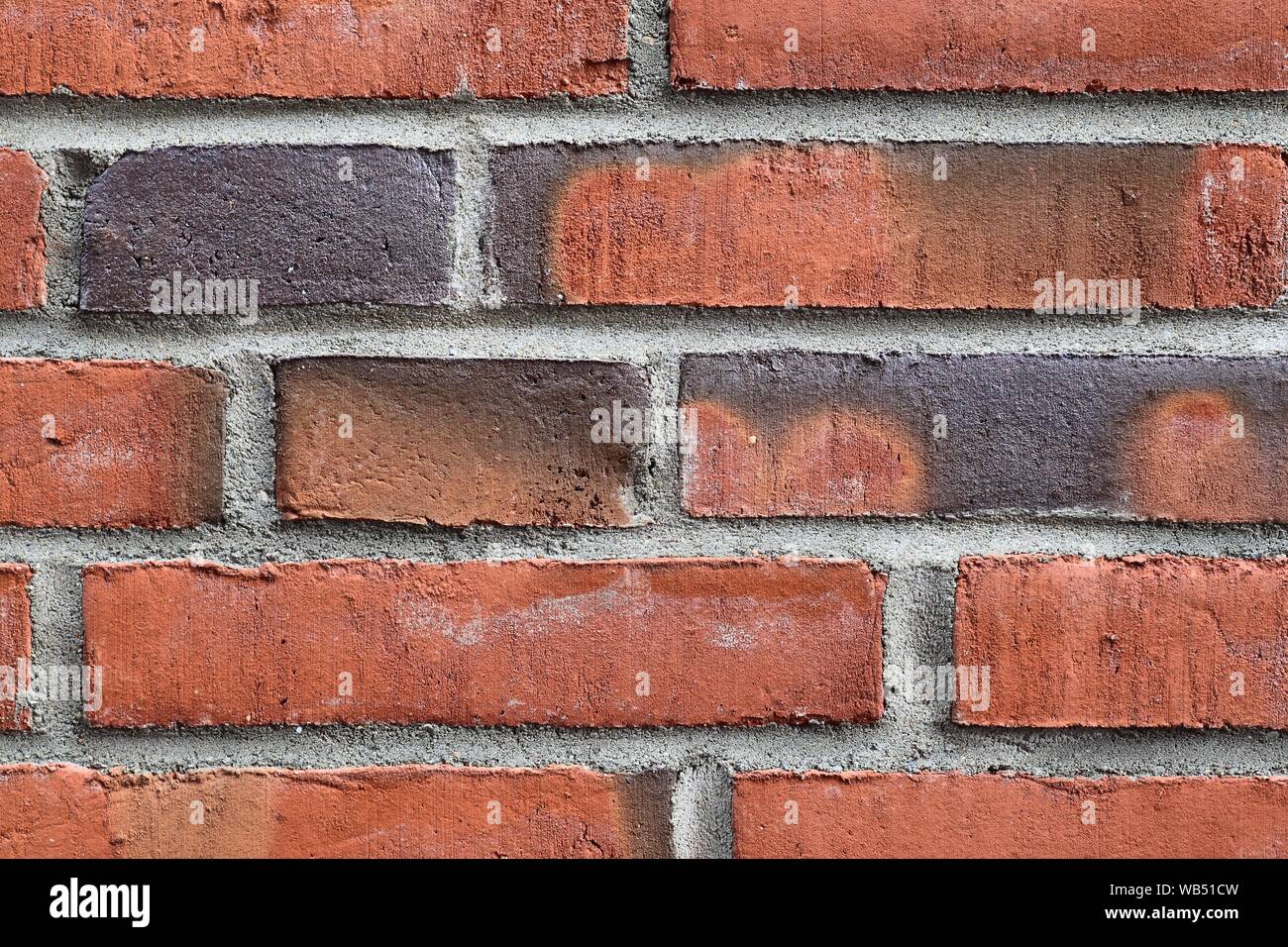 Detailed close up view on an aged and weathered red brick wall texture ...