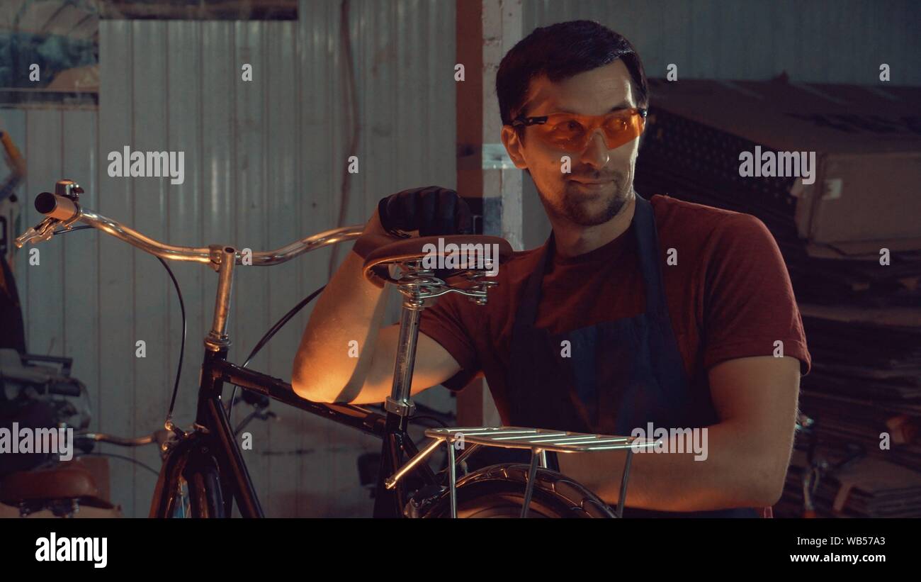 theme small business bike repair. A young Caucasian brunette man ...