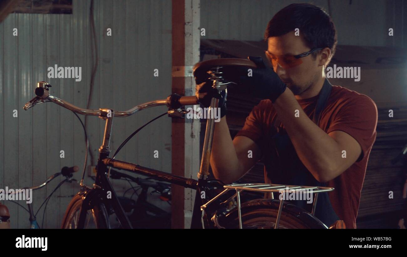 theme small business bike repair. A young Caucasian brunette man ...