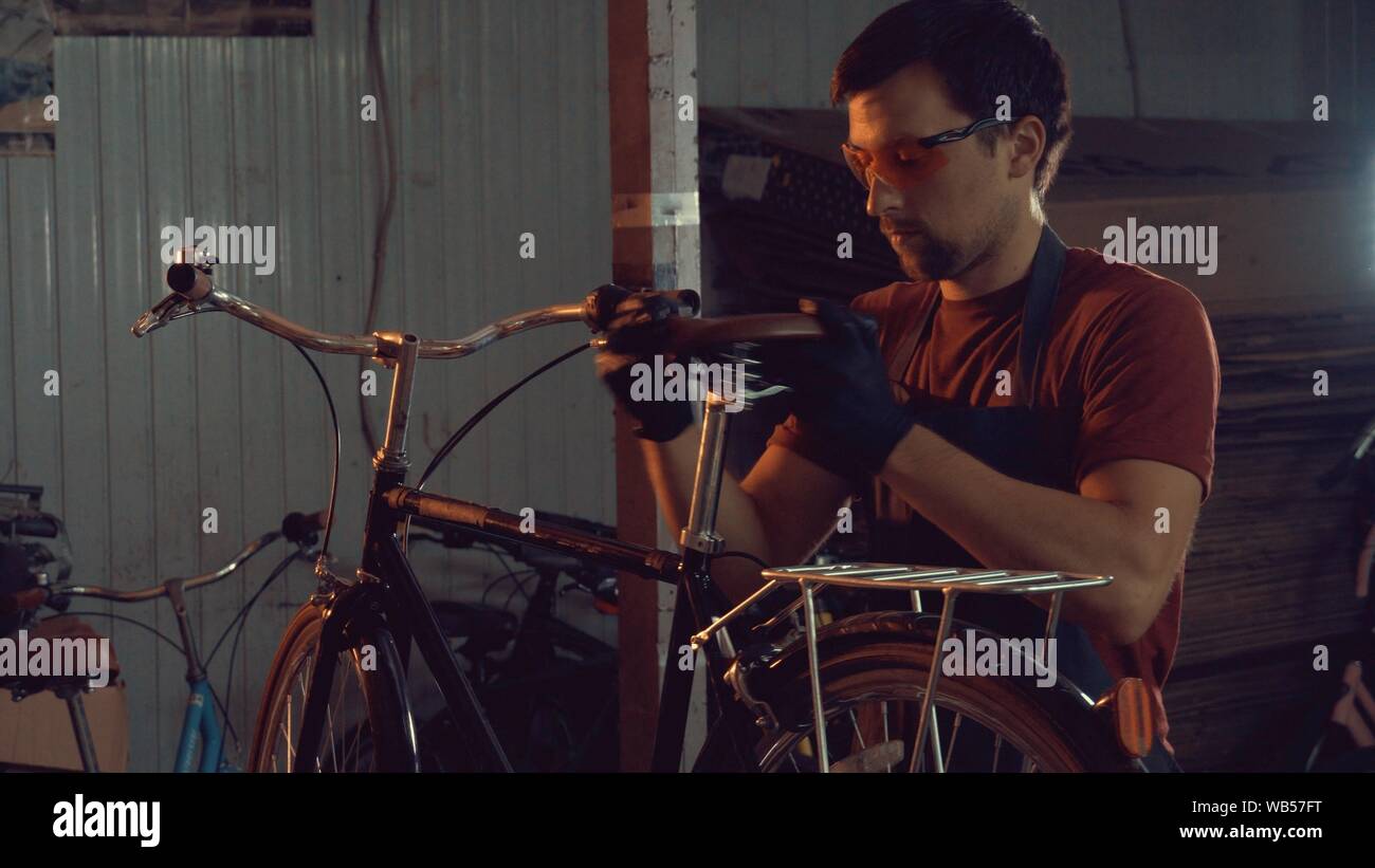 theme small business bike repair. A young Caucasian brunette man ...