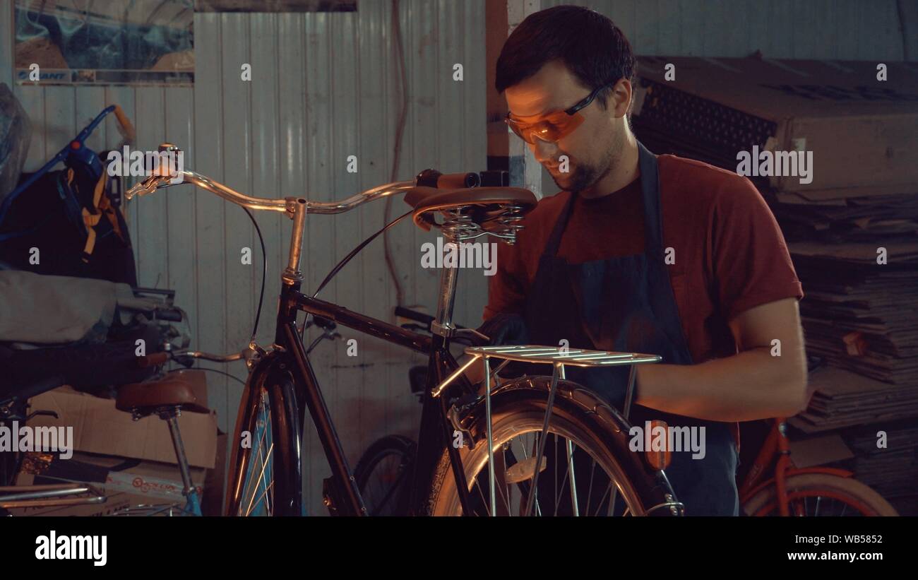 theme small business bike repair. A young Caucasian brunette man ...