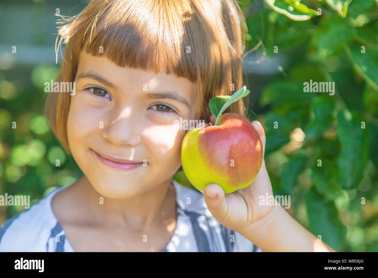 child with an apple in the garden. Selective focus Stock Photo - Alamy