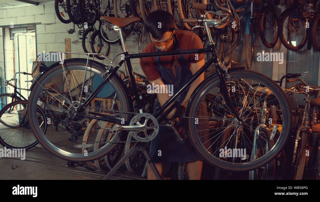 theme small business bike repair. young Caucasian brunette man wearing ...
