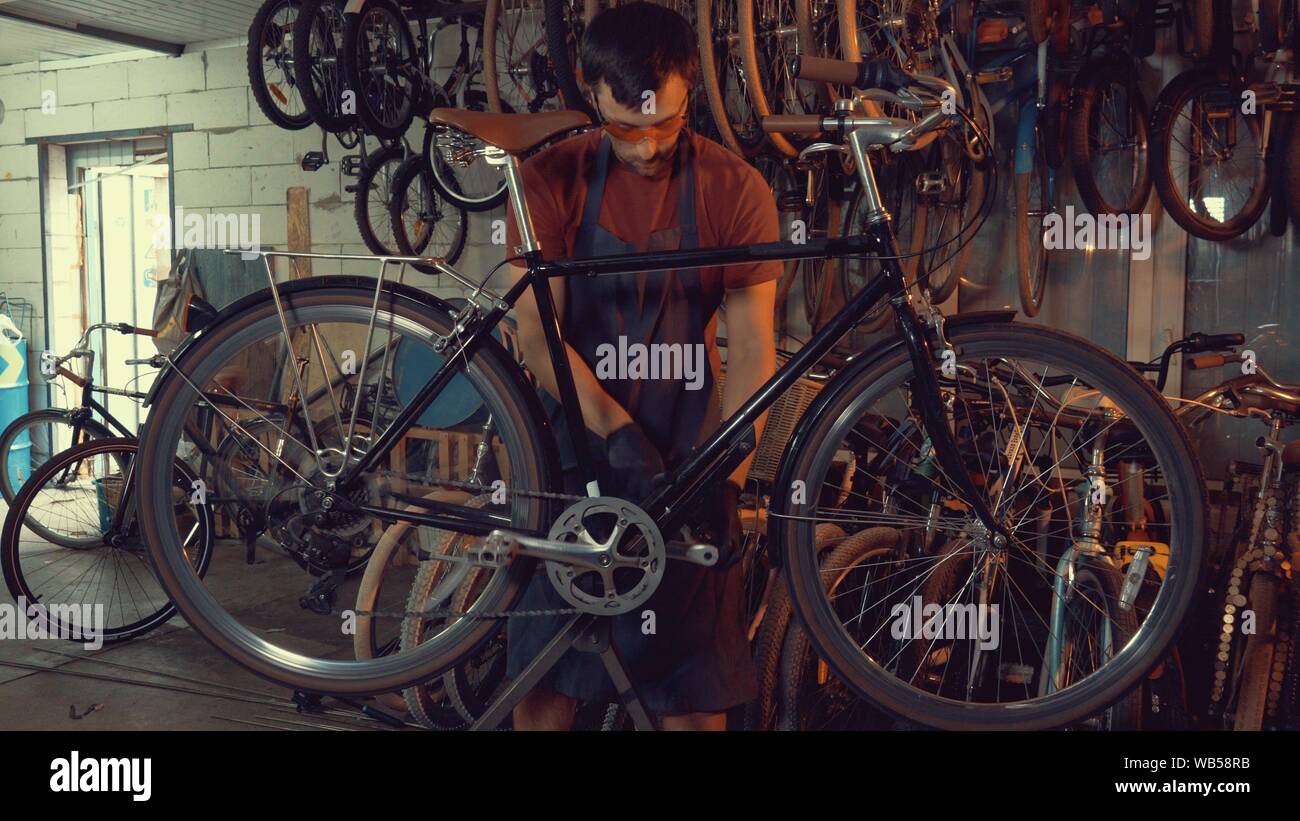 theme small business bike repair. young Caucasian brunette man wearing ...