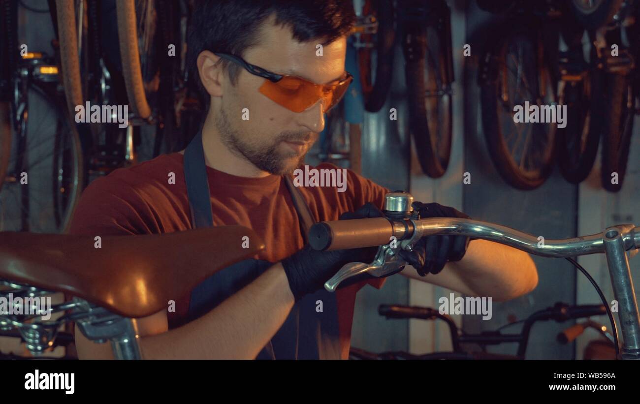 theme small business bike repair. A young Caucasian brunette man ...