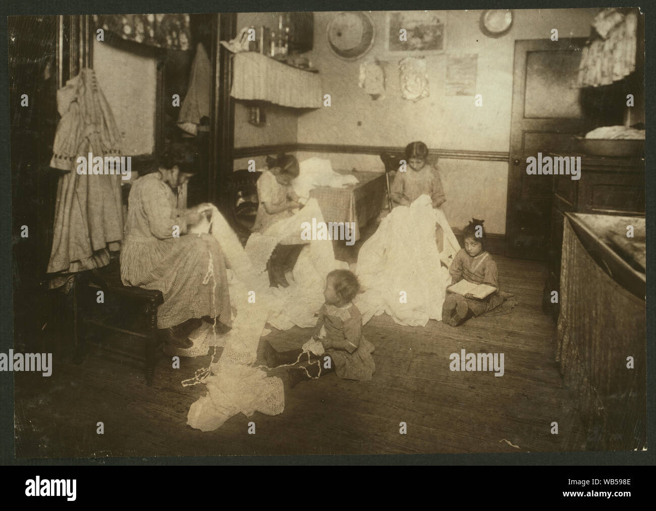 Embroidering chiffon waists in crowded bed-room, East Side. (For ...