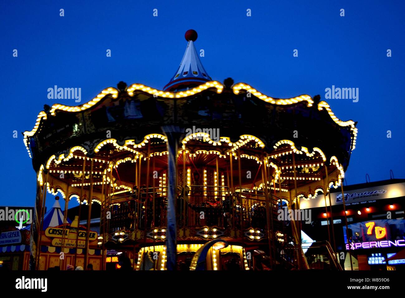 Wide shot of a Merry-go-round carousel at an amusement park during ...