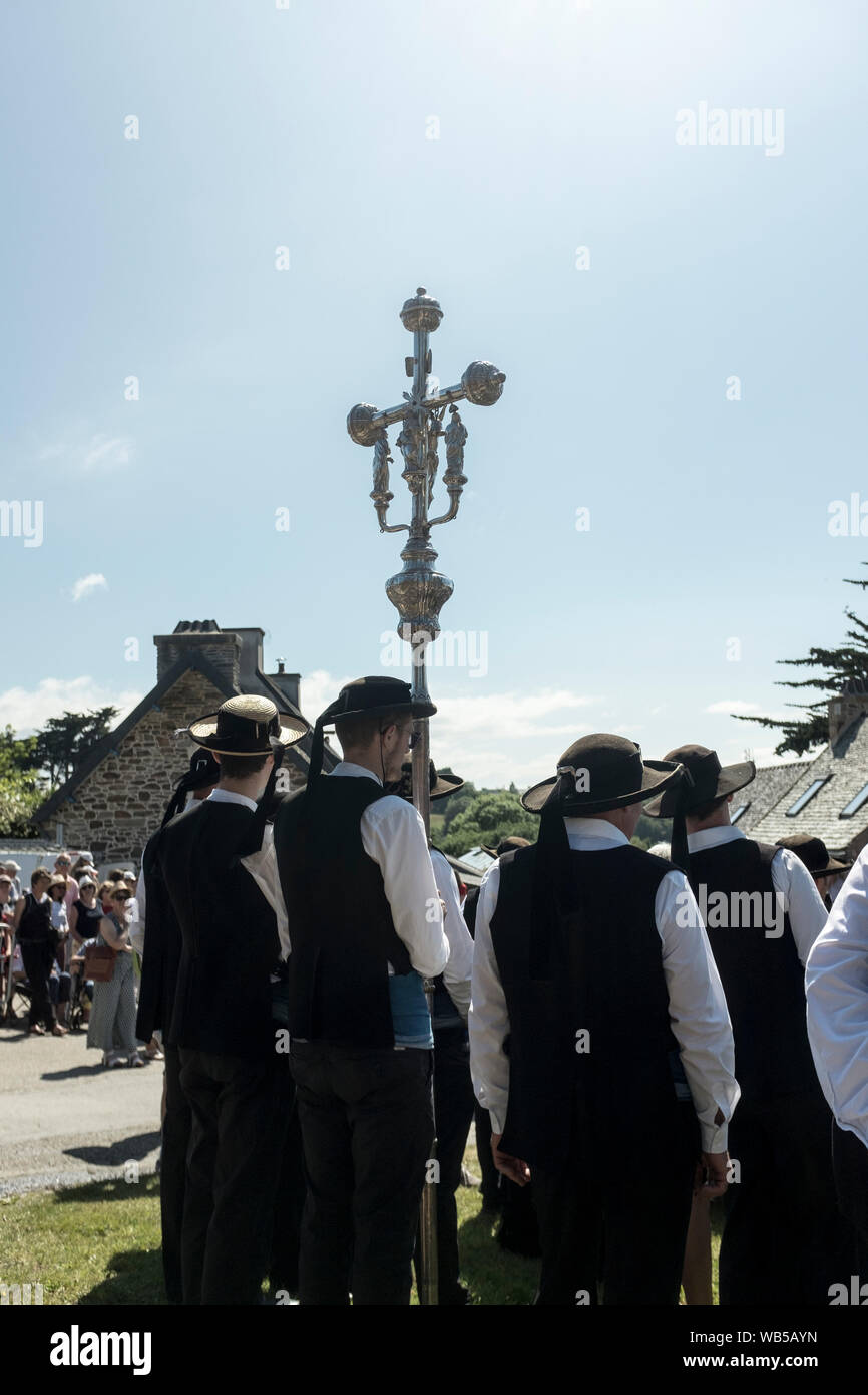 Celebrants in traditional dress carrying a processional cross during ...